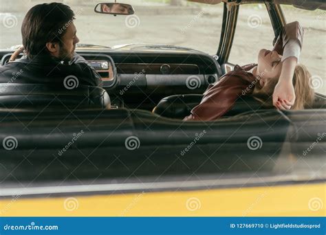 Homem à Moda Que Conduz O Carro E Que Olha A Amiga Sensual Bonita Foto
