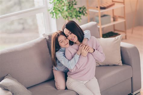 사진 의 낙관적 인 갈색 머리 빨간 머리 엄마 딸 포옹 폐쇄 눈 에 소파 착용 스웨터 에 집에서 2명에 대한 스톡 사진 및 기타