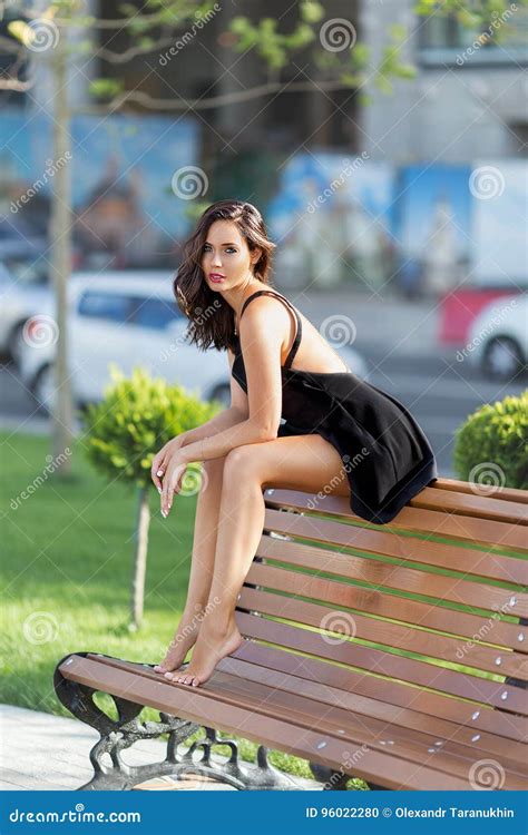 Donna Che Si Siede A Piedi Nudi Sul Banco Fotografia Stock Immagine