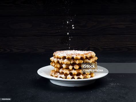 수 제 벨기에 와플 검은색 아주 맛 있는 간식에 가루 설탕의 선별 부 위에 화이트 플레이트 오래 된 나무 테이블 설탕 어두운