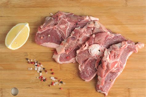 나무 보드에 스테이크의 형태로 원시 양고기 양고기 옆에는 레몬과 소금 조각이 후추를 얹은 것입니다 위에서 볼 수 있습니다 0명에 대한 스톡 사진 및 기타 이미지 Istock