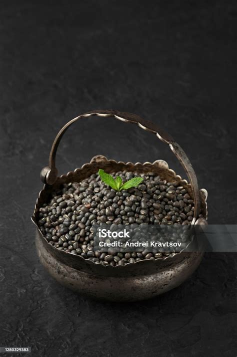 검은 그람 또는 우라콩 또는 문콩 의 힙은 어두운 슬레이트 테이블 상단에 철 바구니 위에 녹색 잎을 얹습니다 비냐 문고는 인기