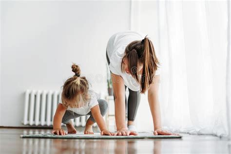 Happy Mom And Little Daughter Doing Morning Exercise Together At Bright