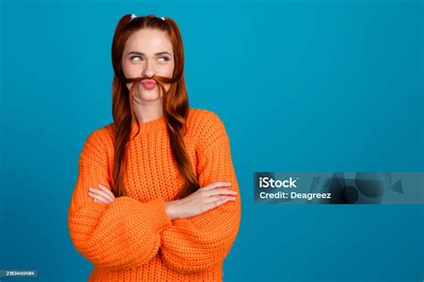 Thouhgtful 예쁜 아가씨 오렌지 풀오버 포니 테일 만들기 가짜 콧수염 빈 공간 고립 된 파란색 배경 인공적인에 대한 스톡 사진 및 기타 이미지 Istock