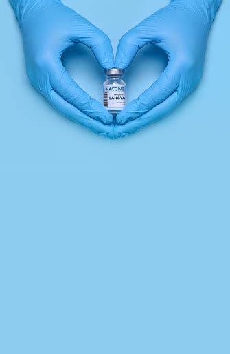 보호 의료용 장갑을 착용한 의사의 손에는 Langya Henipavirus 백신 한 병이 파란색 배경에 심장 모양의 제스처로