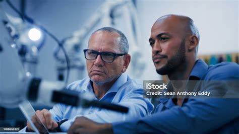 자동화 로봇 및 기계에 대한 검사 분석 및 엔지니어링 설계를 위한 실험실의 남성 미래형 창고 팀워크 및 남성 엔지니어는 공장에서 로봇 시스템 제어 또는 연구에 중점을 둡니다