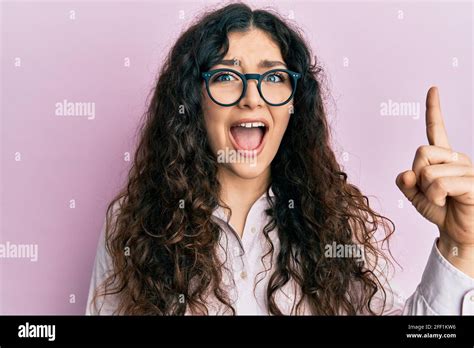 Young Brunette Woman With Curly Hair Wearing Casual Clothes And Glasses