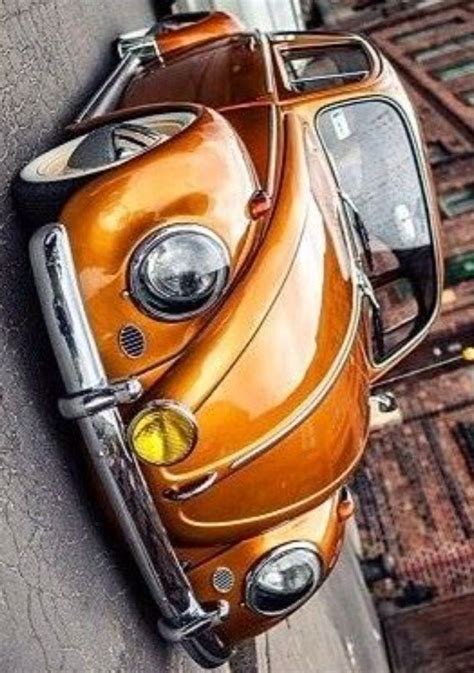 Orange Vw Bug Parked On The Side Of A Building