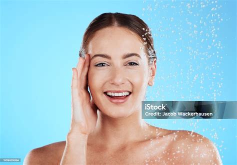 샤워 물 그리고 스튜디오에서 청소와 스킨케어를 하는 행복한 여자의 초상화 피부과에서 흥분한 여성 모델의 웰빙 스플래시 및 뷰티 루틴과 파란색 배경의 셀프 케어 25 29세에
