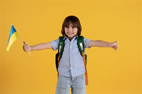 훌륭한 국가 교육 배낭을 메고 우크라이나 국기를 들고 엄지손가락을 치켜드는 제스처를 보여주는 어린 소년 미취학 아동 4 5세에