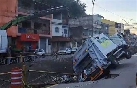 Asfalto cede e caminhão de lixo é engolido por cratera em Volta