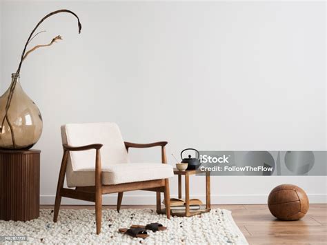 Boucle 안락 의자 나무 커피 테이블 Pedant 램프 꽃병의 아름다운 잎 장식 및 개인 액세서리가있는 미학적이고 미니멀 한 거실의 인테리어 디자인 공간을 복사합니다