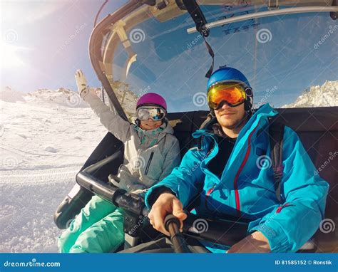 Счастливые пары принимая Selfie в подвесном подъемнике на лыжный курорт