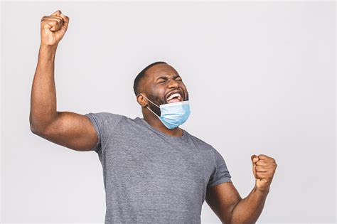 흰색 배경에 고립 된 포즈 멸균 얼굴 마스크에 행복 한 젊은 아프리카 계 미국인 남자 전염병 확산 코로나 바이러스