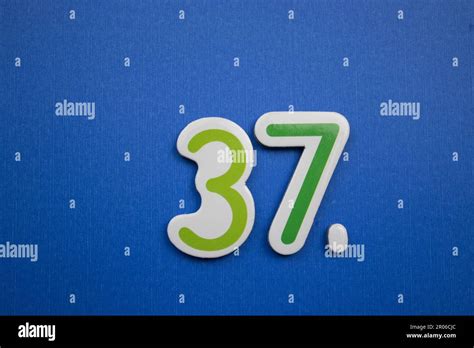 The Number 37 Placed On A Blue Background Photographed From Above