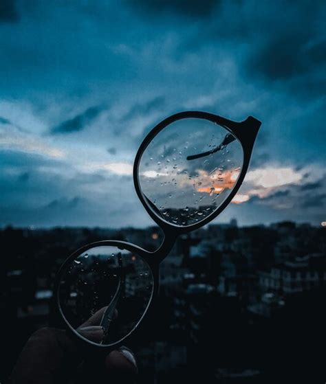 Premium Photo Close Up Of Hand Holding Sunglasses Against Sky