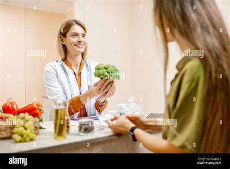 Nutritionist With Young Woman Client Talking About Meal Plan And