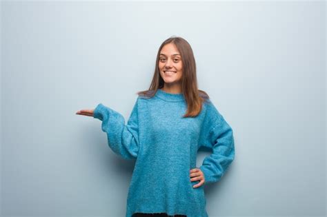 Premium Photo Young Pretty Woman Wearing A Blue Sweater Holding