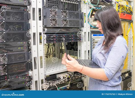 A Woman With A Laptop Works In A Server Room The Girl Programmer
