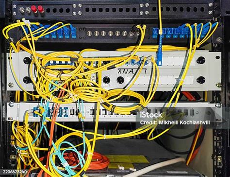 네트워크 스위치의 뒷면은 케이블 연결부가 있는 랙에 볼트로 고정되어 있습니다 많은 노란색 및 청록색 광 케이블 선반 제작물에 대한 스톡 사진 및 기타 이미지 Istock