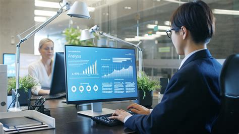 그의 책상에 사무실 사업 작품에서 그는 그것의 스크린에 보여주는 정보를 통계와 함께 사용 하 여 개인용 컴퓨터입니다 2명에 대한 스톡 사진 및 기타 이미지 Istock