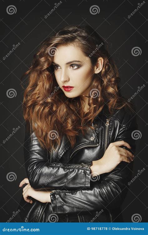 Beautiful Young Woman Posing In Black Leather Jacket Over Grey B Stock