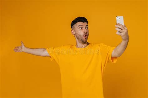 Surprised Man Taking Selfie With Outstretched Hand Isolated Over Yellow