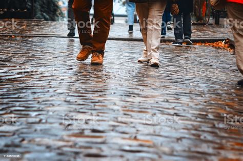 비오는 가을 날 젖은 포장도로를 걷는 신발을 신고 사람들의 발을 바라보는 정면 공간을 복사합니다 가을 라이프 스타일 남자와 여자는 야외에서 비오는 날씨에 함께 산책 자갈