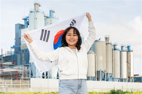 공장을 배경으로 한국의 국기를 들고 있는 행복한 젊은 여자 18 19세에 대한 스톡 사진 및 기타 이미지 18 19세 감정