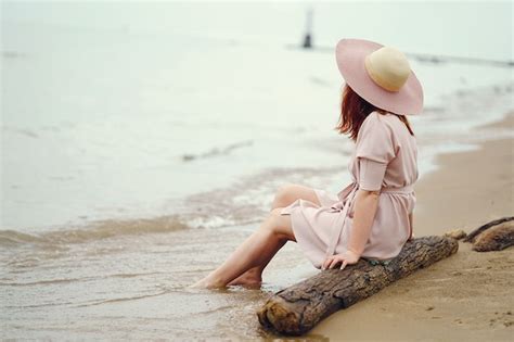 Une Jeune Fille Rousse Dans Un Grand Chapeau Rond Et Robe Rose Assis