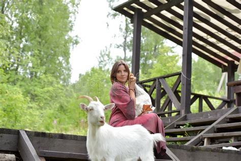 Femme Dans La Robe De Bourgogne Une Ferme Avec Une Oie Image Stock