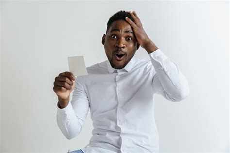 놀란 행복 표현과 젊은 아프리카 남자는 회색 스튜디오 배경에 내기를 받았다 아프리카 민족에 대한 스톡 사진 및 기타 이미지