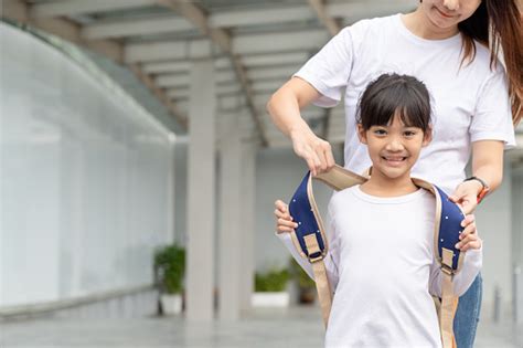 초등학교의 학부모와 제자가 손을 잡고 있습니다 뒤쪽에 배낭을 가진 여자와 소녀 수업 첫날시작 2명에 대한 스톡 사진 및 기타