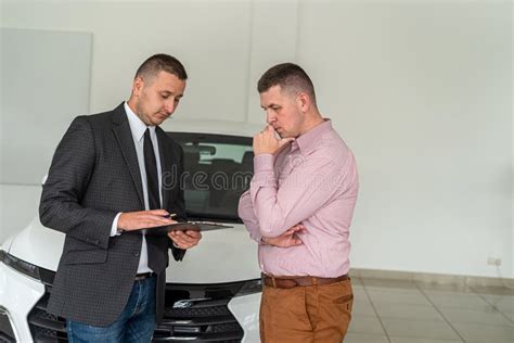 Seller Holding A Clipboard Tells The Client All The Details Of The