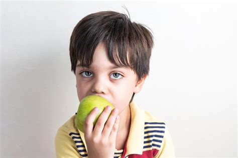 Garoto Bonito Comendo Maçã Verde Foto Grátis