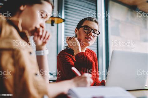 젊은 관심 힙스터 소녀 안경에 그녀의 여성 친구를 만드는 계획을 찾고 캠퍼스에서 동료와 노트북 장치와 시간을 보내는 영리한 백인 여성 인터넷에 대한 스톡 사진 및 기타