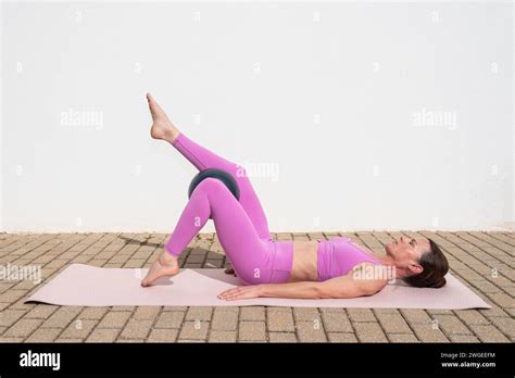Fit Sporty Woman Doing Pilates Ball Exercises Outside Toe Tap Exercise