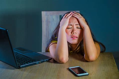 극적인 초상화 무서 워 하 고 아시아 한국 십 대 소녀 또는 젊은 노트북 컴퓨터와 휴대 전화 사이버 스토킹과 인터넷 비밀 번호