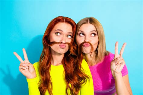 생생한 청록색 배경을 배경으로 밝은 여름 의상을 입고 손가락 콧수염을 기르고 포즈를 취하는 장난기 많은 여자친구들 25 29세에 대한 스톡 사진 및 기타 이미지 Istock