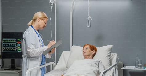 병동에서 수술 후 침대에 누워있는 환자의 의료 카드를 채우는 흰 코트의 간호사 사진 Unsplash의 코로나 바이러스 이미지
