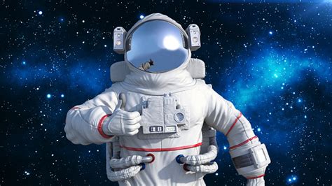 นักบินอวกาศใน Spacesuit แสดงนิ้วหัวแม่มือขึ้น นักบินอวกาศลอยอยู่ในอวกาศ