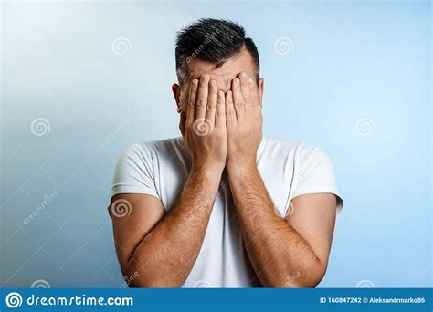 Close Up Portrait Of A Man Covering His Face With His Hands On A