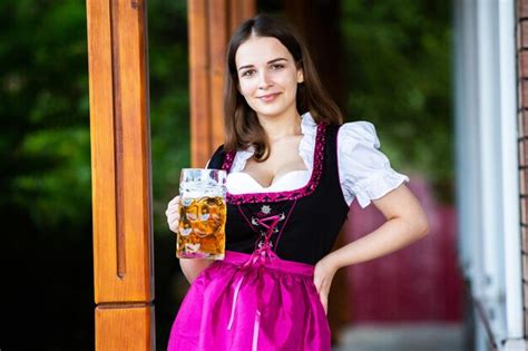 Premium Photo The Beautiful Brunette Holds Pints Of Beer At The Oktoberfest In Germany