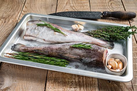 백리향과 로즈마리가있는 강철 부엌 트레이에 생 대구 전체 생선 나무 배경 위쪽 보기 0명에 대한 스톡 사진 및 기타 이미지