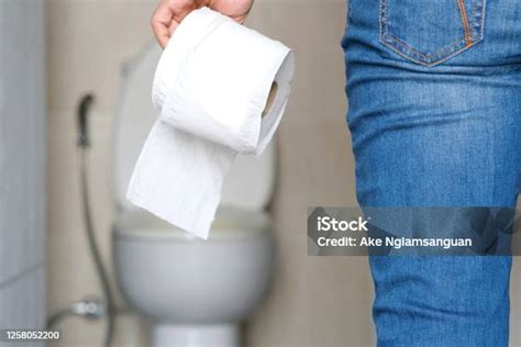 남자의 손 그는 화장실 화장실 배경에 가는 화장지의 롤을 들고 걱정하는에 대한 스톡 사진 및 기타 이미지 걱정하는 맹장