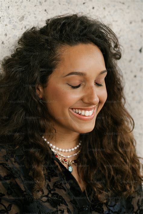 A Woman Smiling While Looking At Her Cell Phone Photo Portrait Image