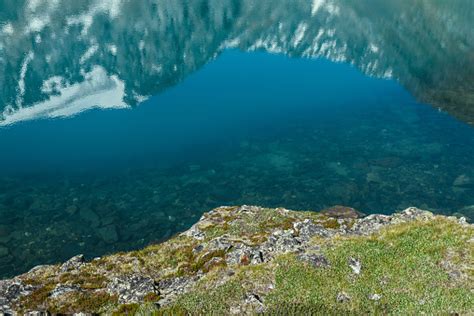 눈 덮인 산은 빙하 호수의 맑은 물에 반영됩니다 산호수의 수면에 눈이 내리는 빙하가 반사되어 있는 아름다운 맑은 풍경 산호수에
