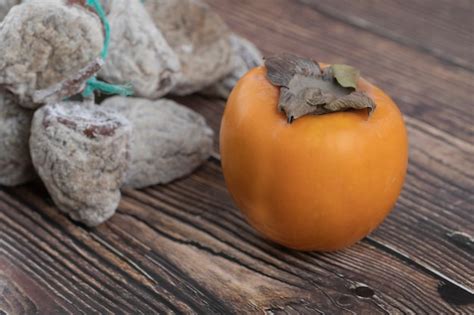 Free Photo Tasty Fuyu Persimmon And Dried Persimmons On Wooden Surface