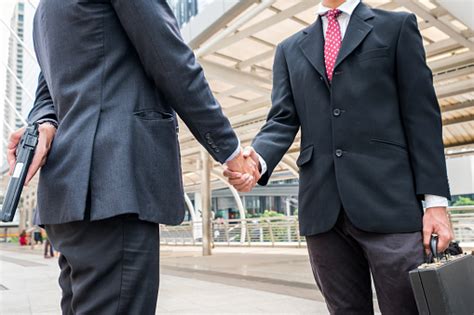 두 사업가 핸드셰이킹 정직 하 고 서류와 총을 들고와 속임수 부정직에 대한 스톡 사진 및 기타 이미지 부정직 일체감 커플