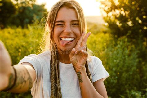 White Young Woman Showing Her Tongue While Taking Selfie Photo Stock